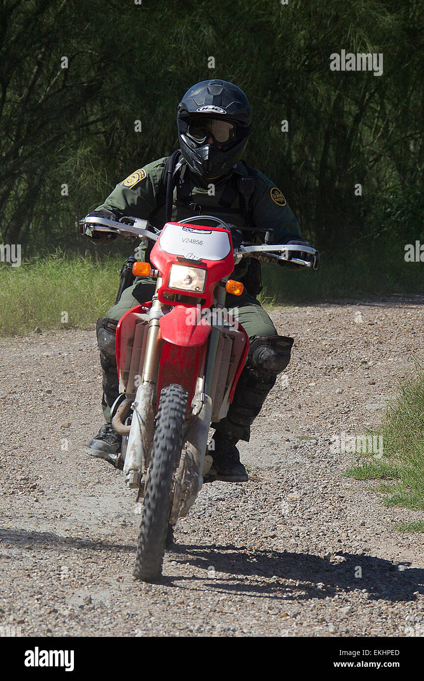 A U.S. Border Patrol agent conducts routine patrols on a dirt bike ...