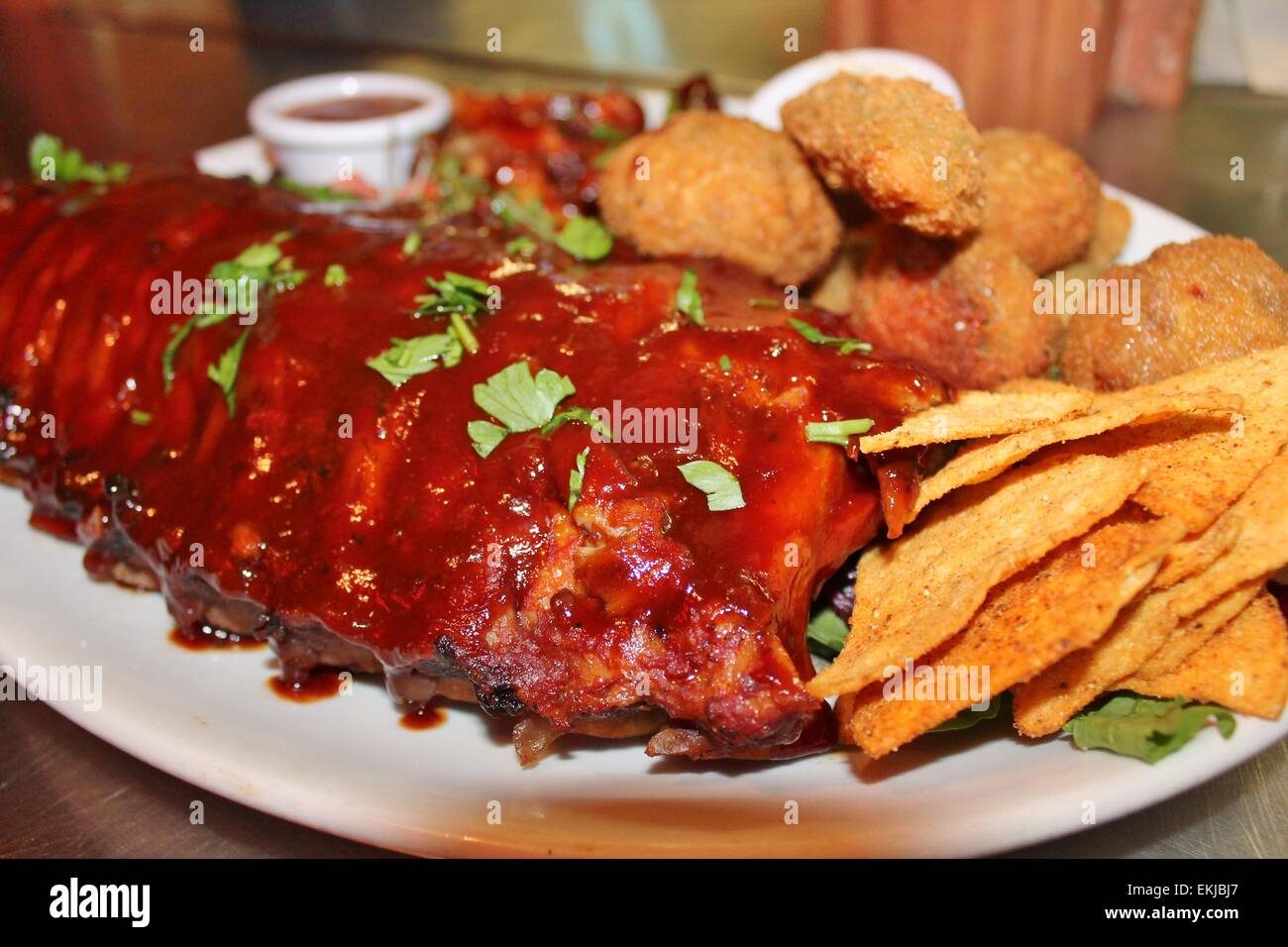 Tex mex BBQ baby back ribs and wings platter with nachos Stock Photo ...