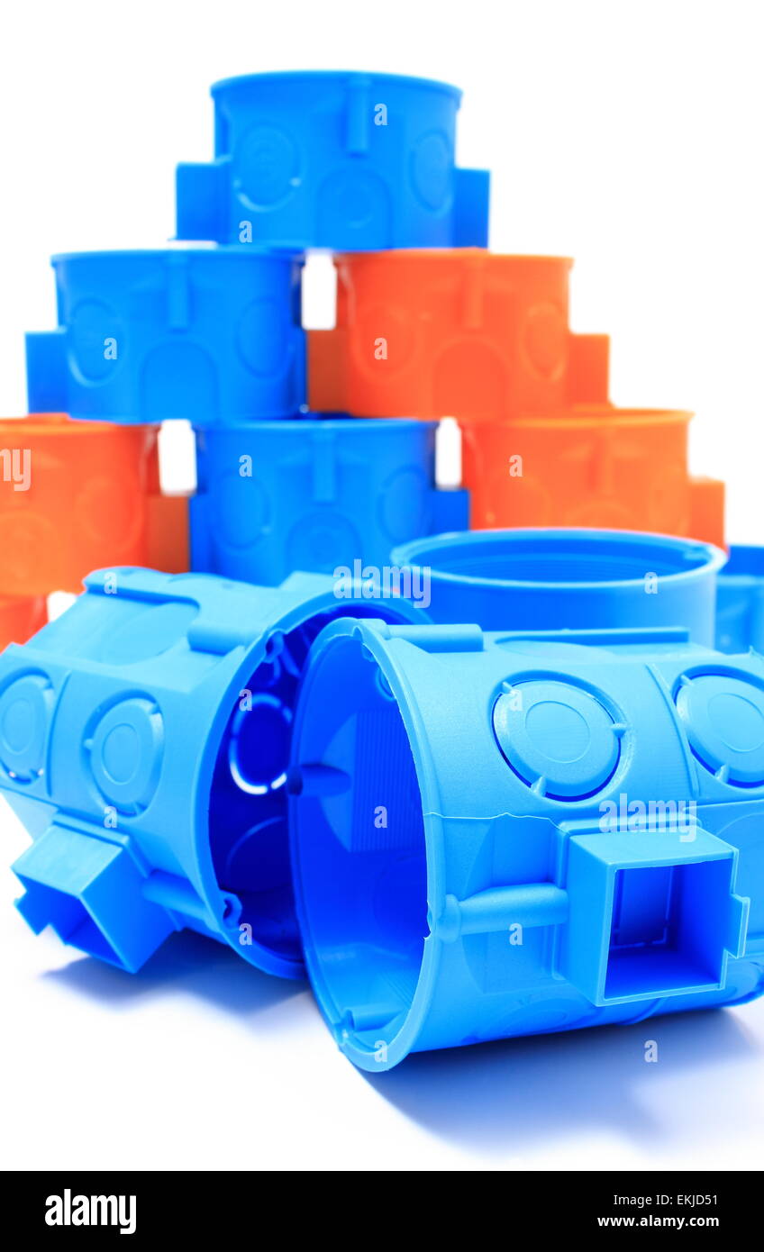 Blue and orange plastic electrical boxes on white background ...