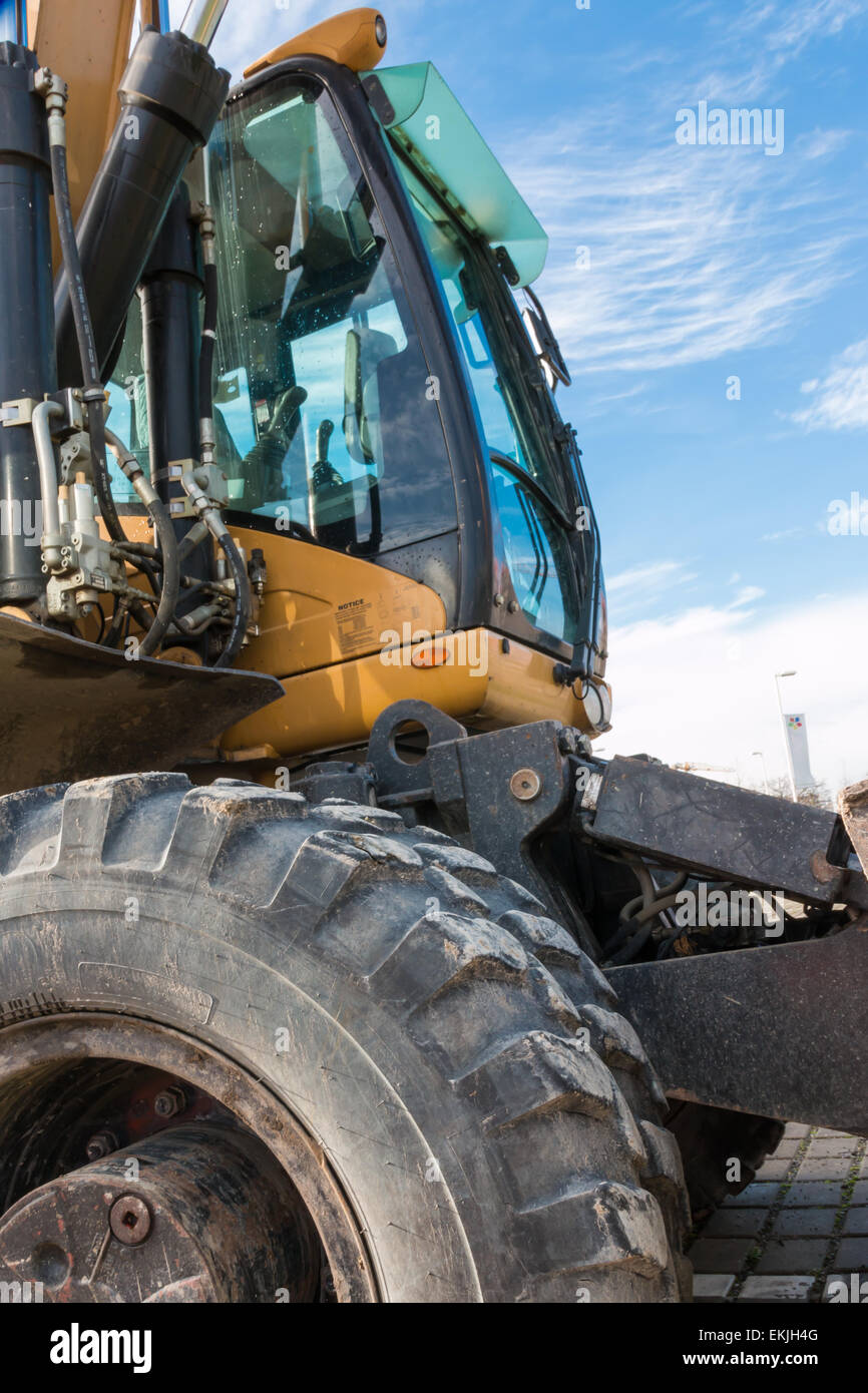 Close-up of yellow loader excavator cabin and tire on the road Stock ...