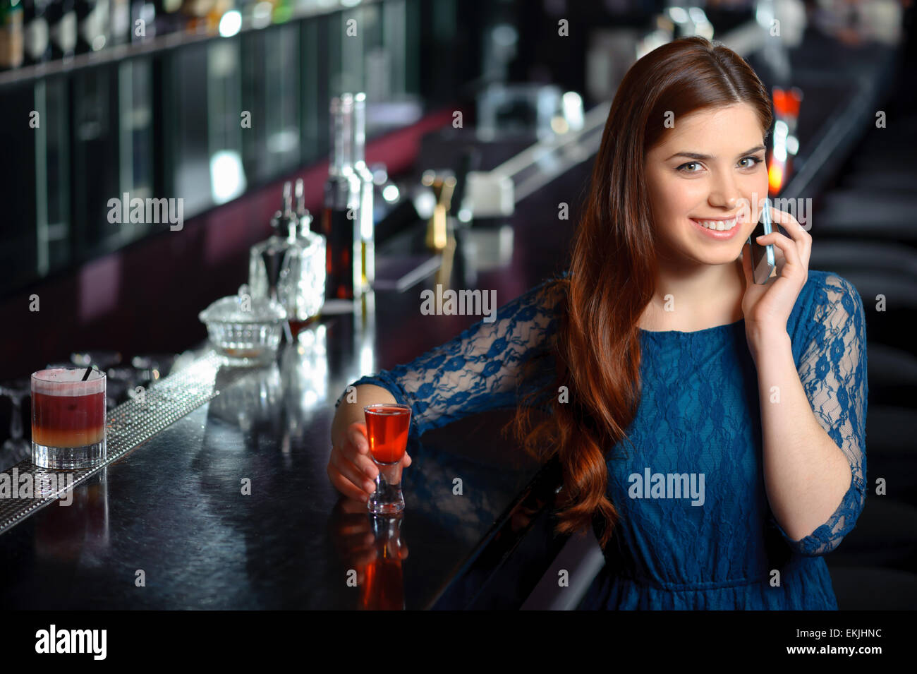 Young woman uses her phone in the bar Stock Photo - Alamy