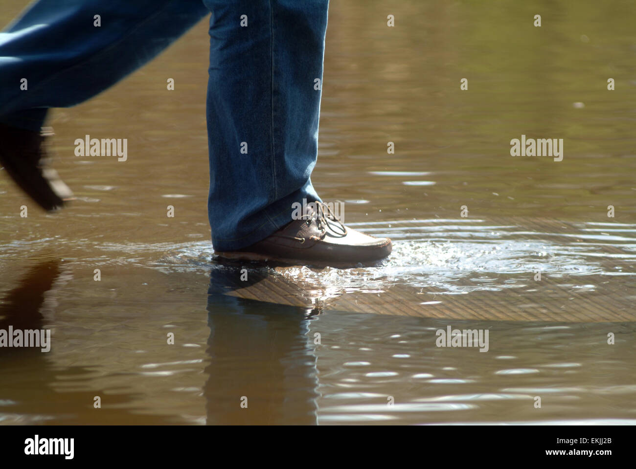 Man walking on water in a water feature park with platform under water ...