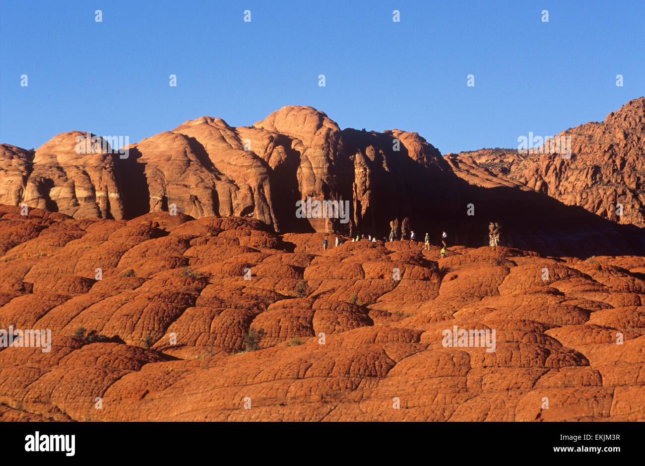 Red Rock formations dwarf hikers at Petrified Sand Dunes, Snow Canyon ...