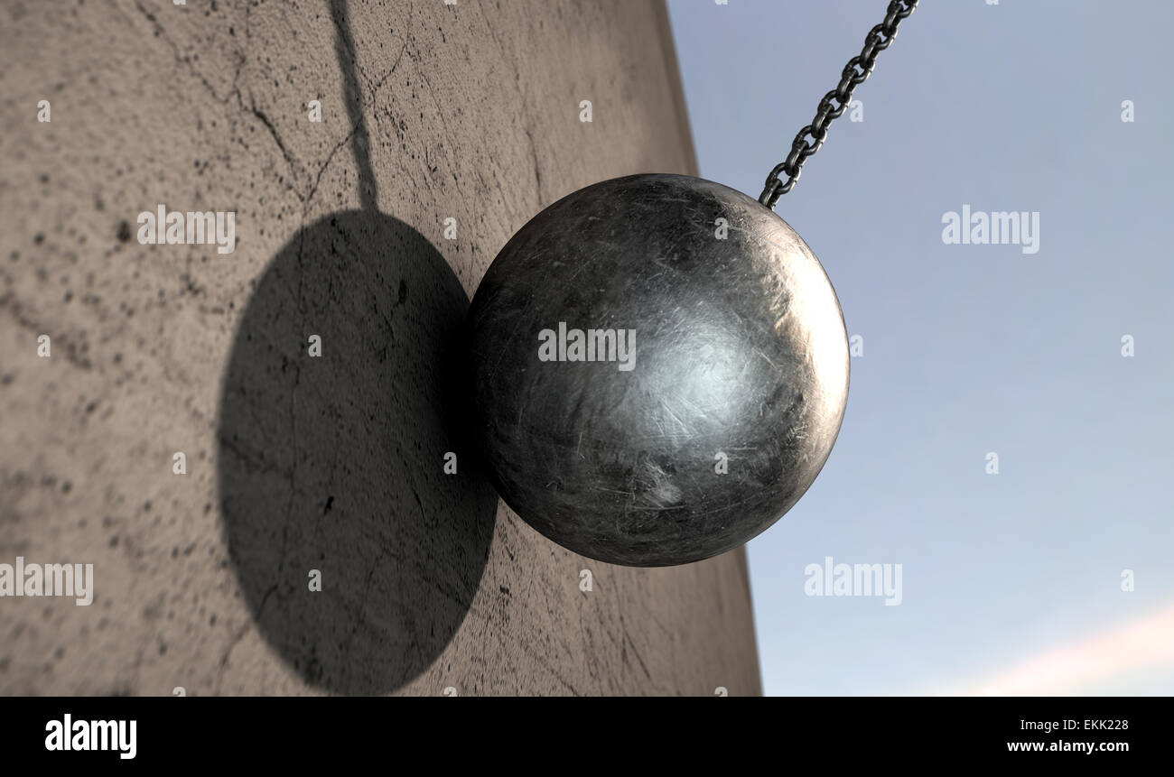 A regular metal wrecking ball attached to a chain hitting a concrete ...
