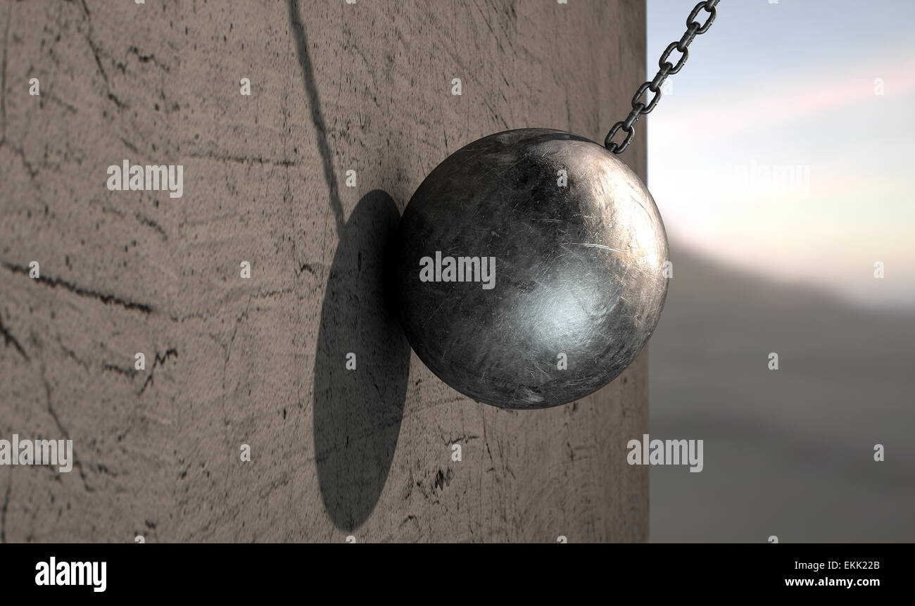 A regular metal wrecking ball attached to a chain hitting a concrete ...