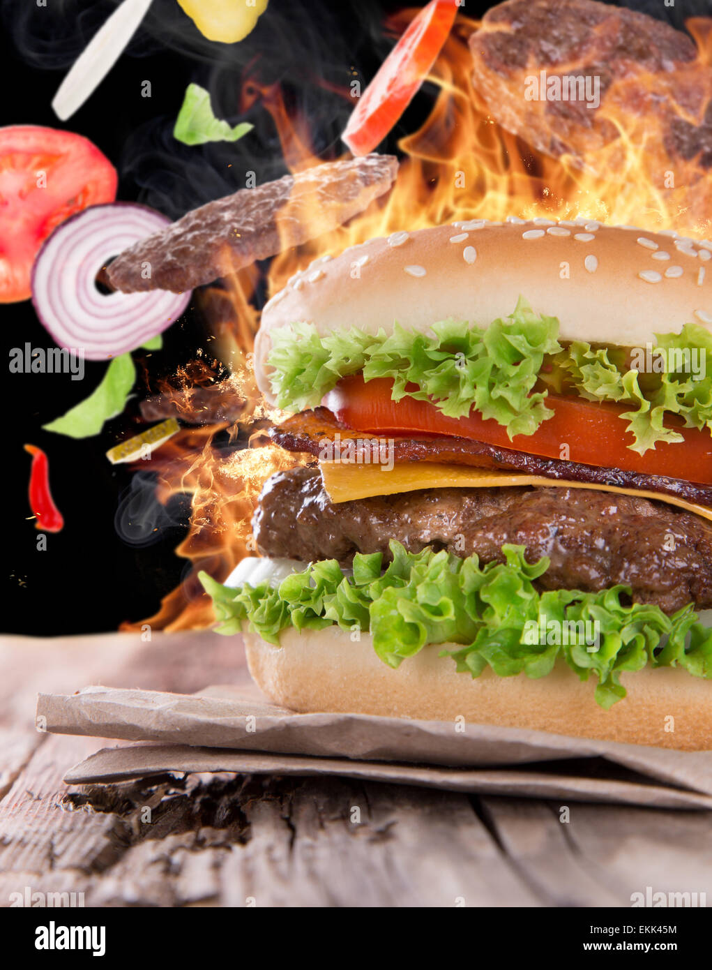 Delicious hamburger with fire flames on wooden background Stock Photo ...