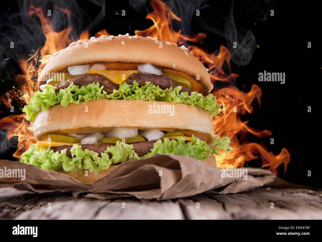 Delicious hamburger with fire flames on wooden background Stock Photo ...
