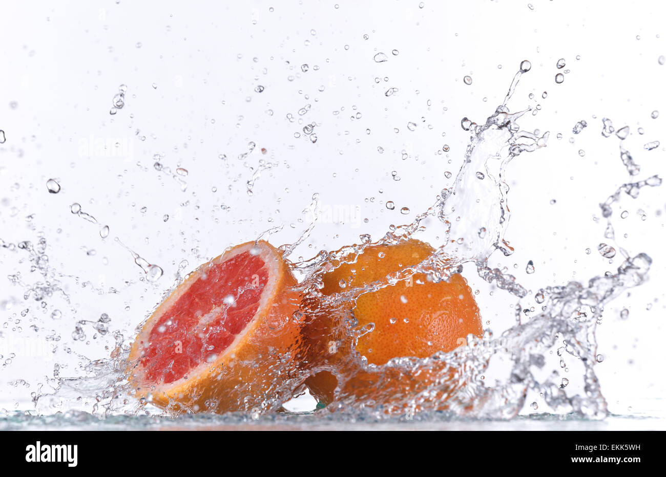 Grapefruit with water splash isolated on white Stock Photo - Alamy