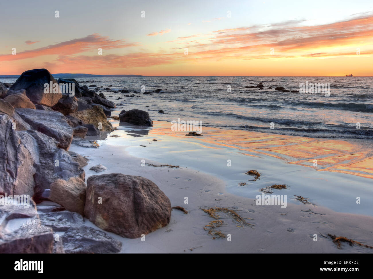 Colourful beach reflections at sunrise Stock Photo - Alamy