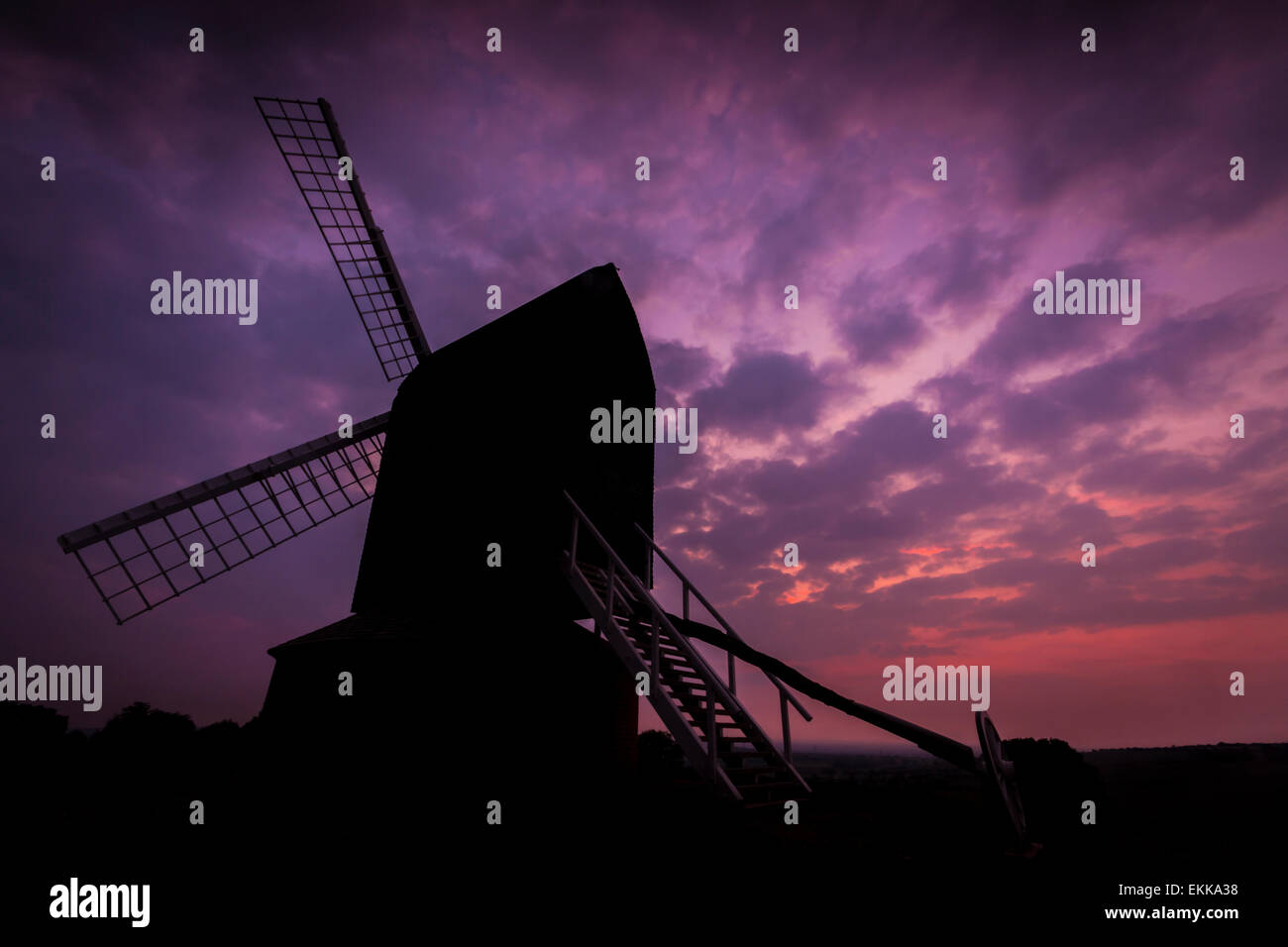 An ancient post mill sits atop of a hill in Buckinghamshire at sunset ...
