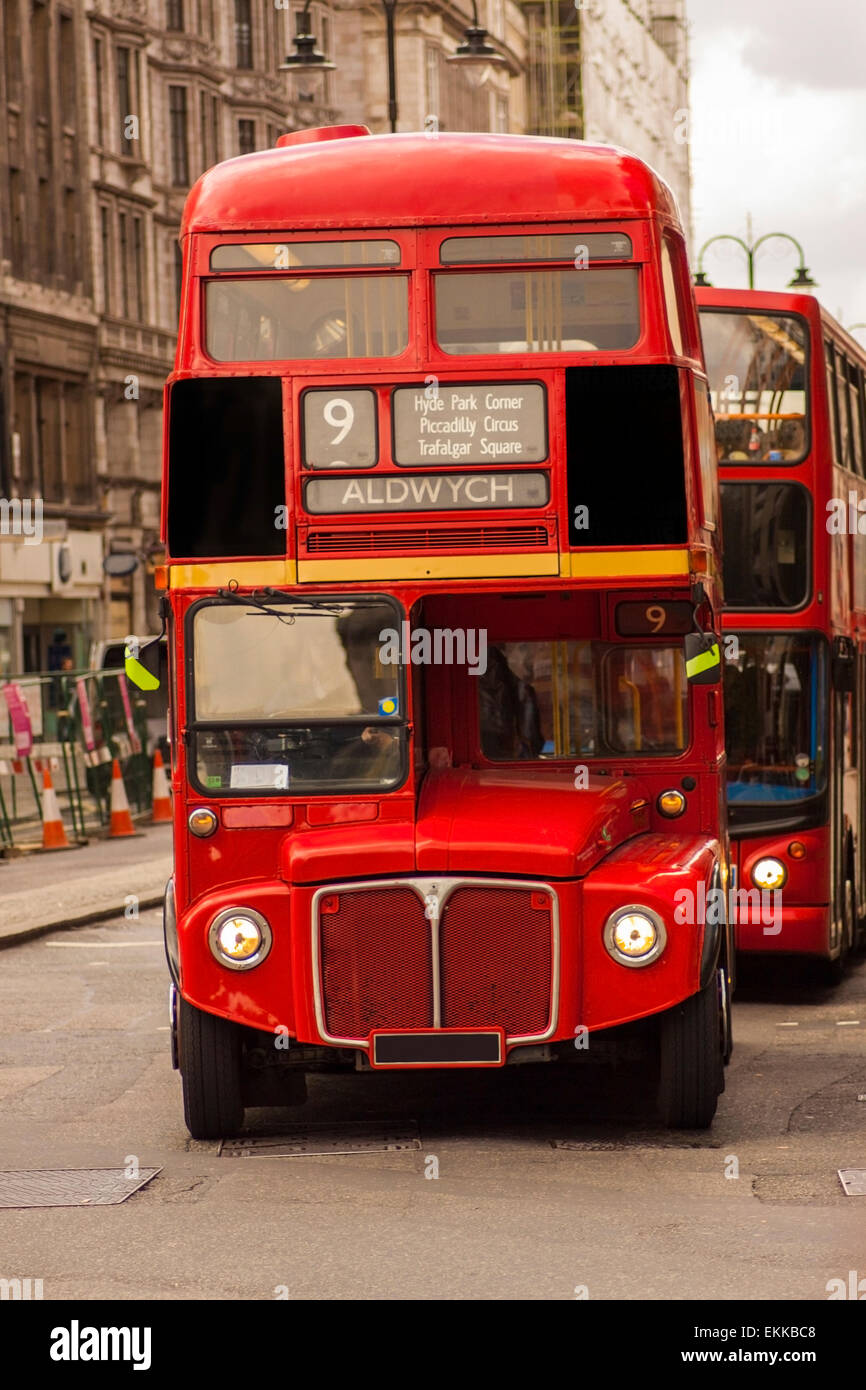Bright, red buses ply their trade in London's bustling streets Stock ...