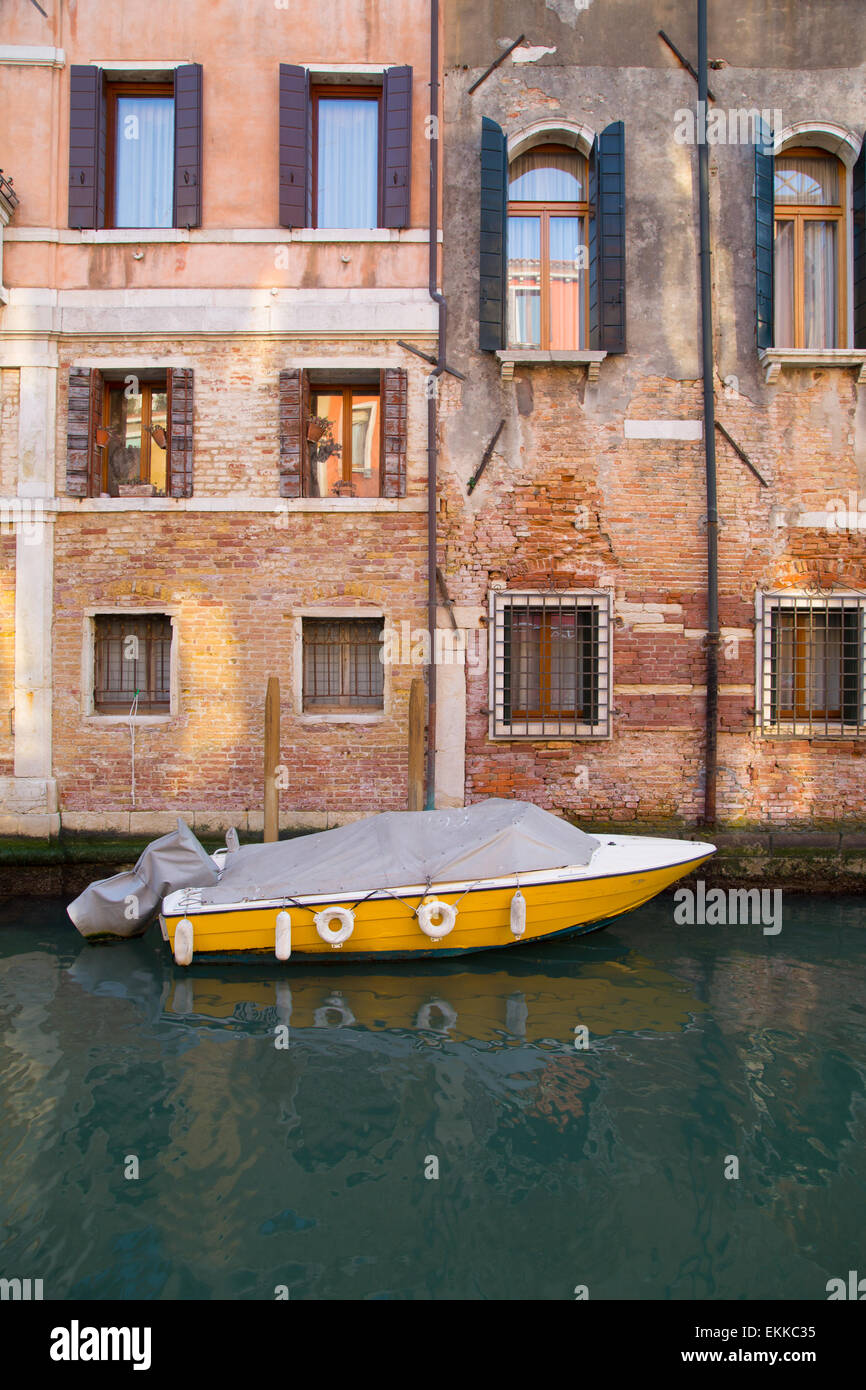 The outside of an old building in Venice. A boat can be seen floating ...