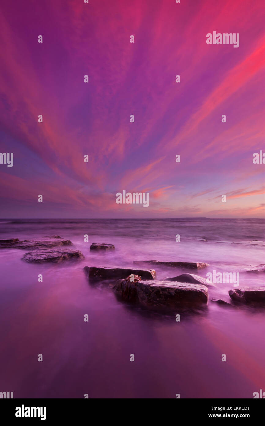 The sun sets on the beautiful Dorset coastline illuminating glistening ...