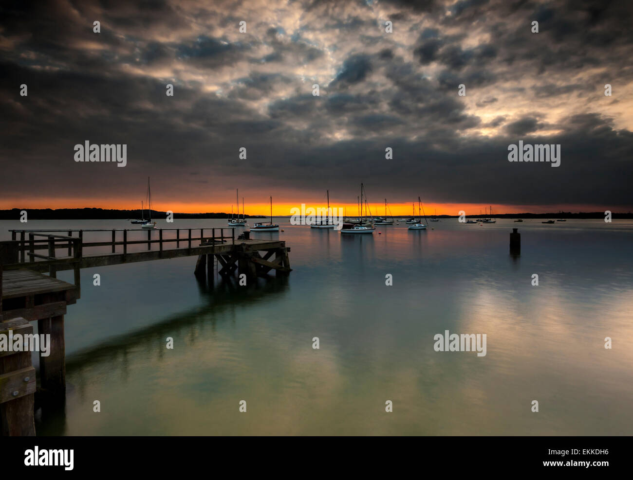 The Sun sets over Poole Harbour in Dorset. Hamworthy pier jetty Stock ...