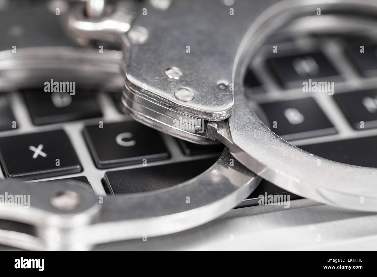 handcuff on keyboard of laptop Stock Photo - Alamy