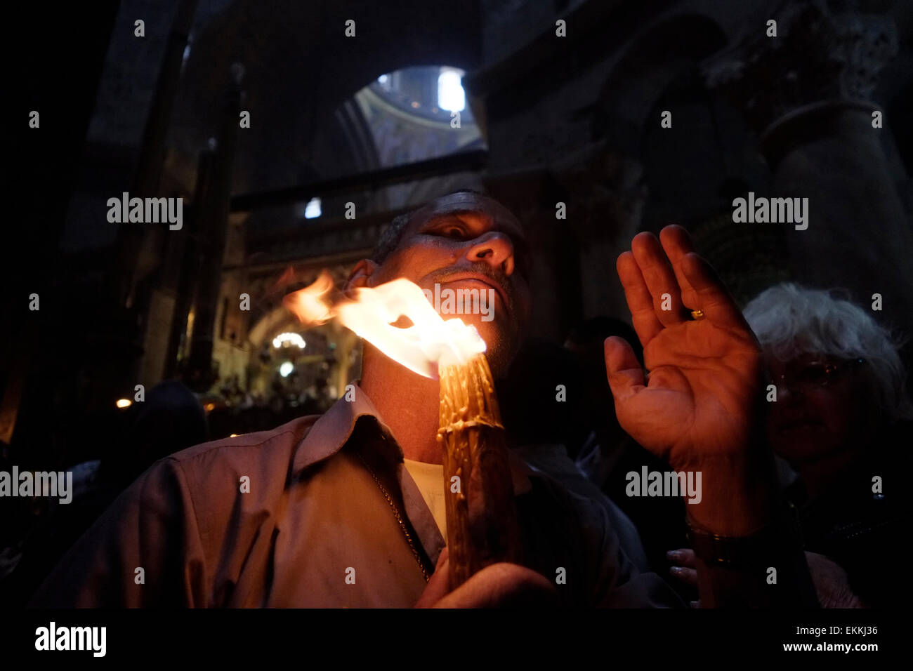 Christian Orthodox worshiper holds up candles lit from the Holy Fire ...