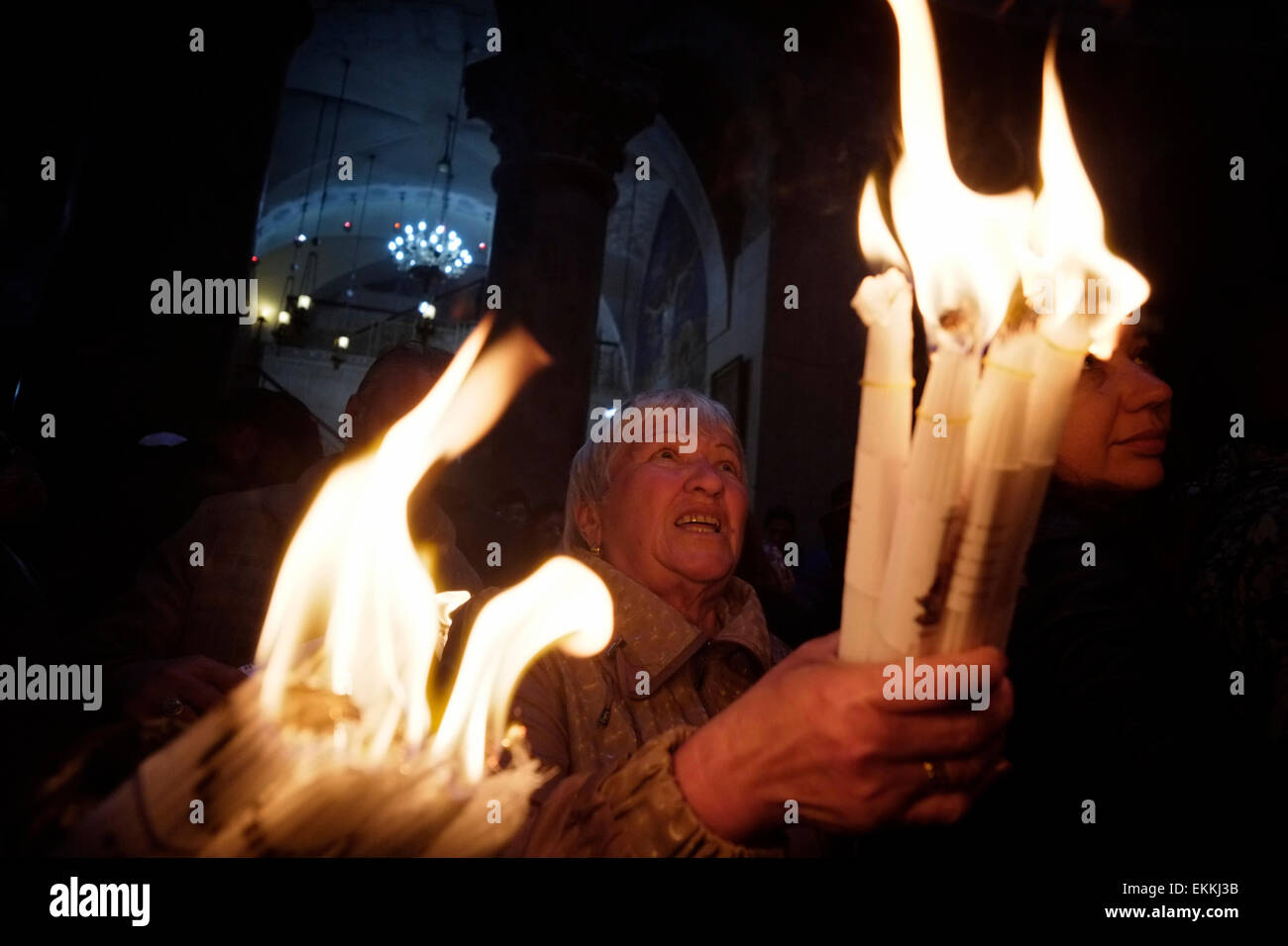Christian Orthodox worshiper holds up candles lit from the Holy Fire ...
