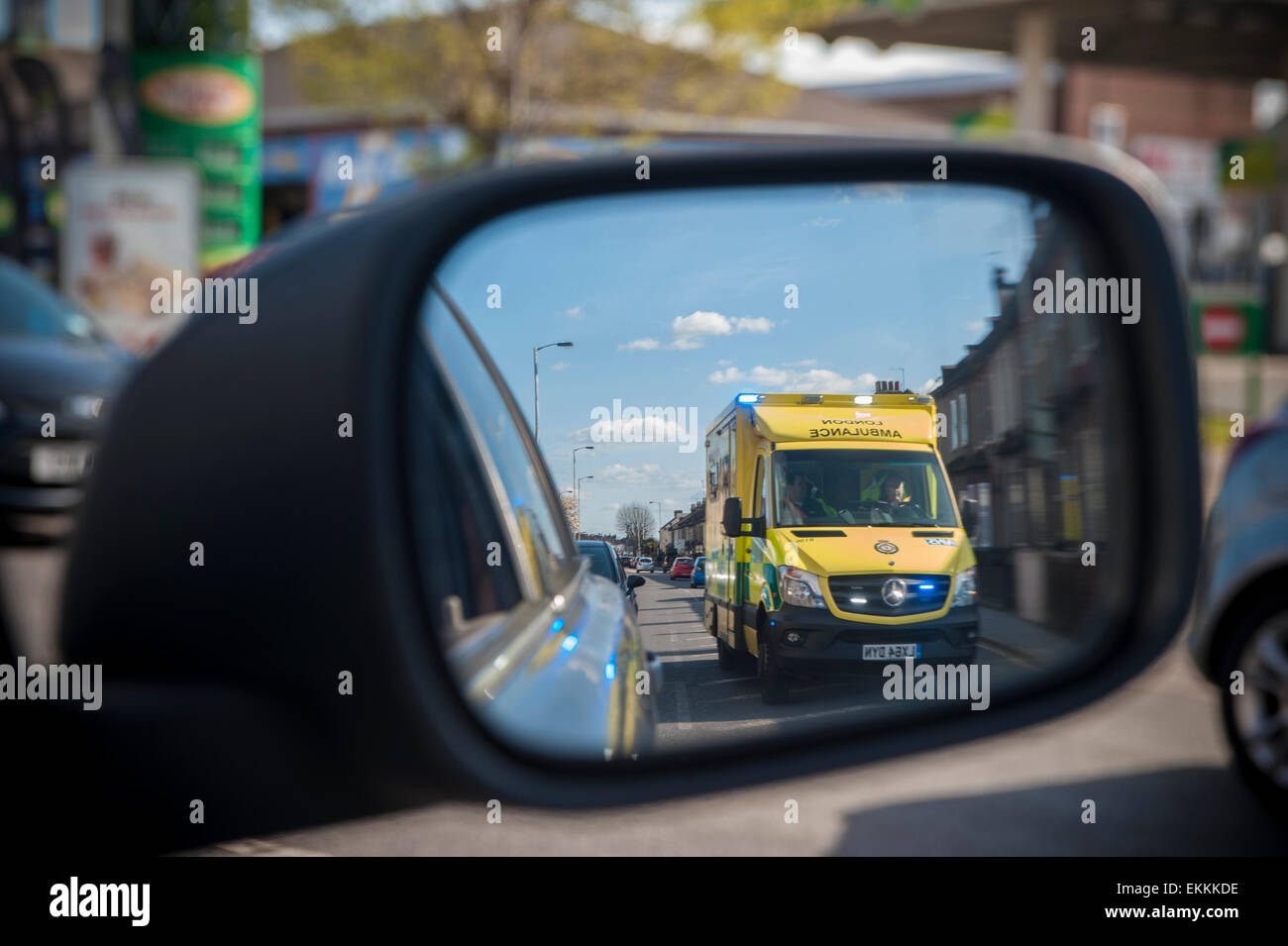 An racing ambulance with flashing lights overtakes a car which sees it ...