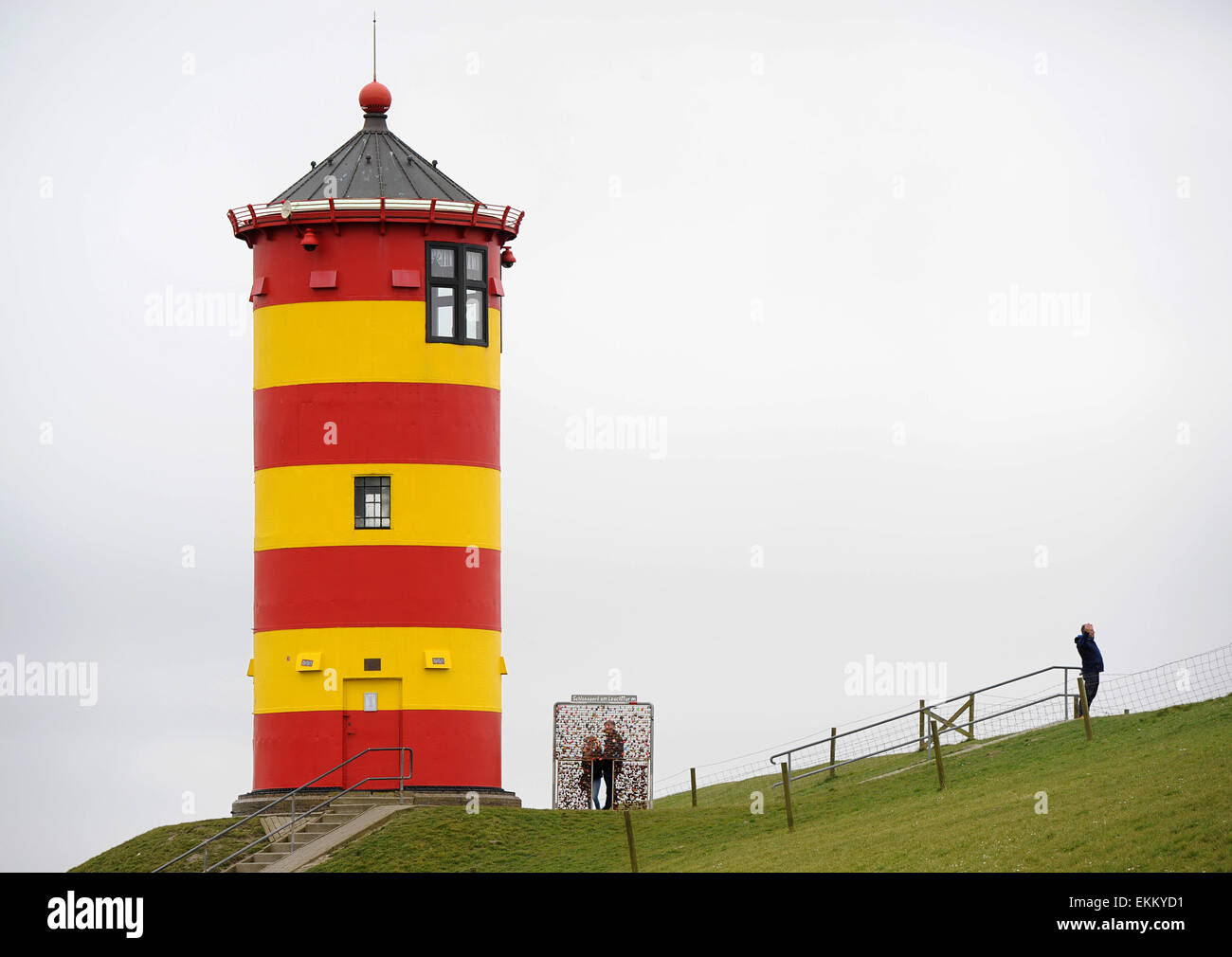 Pilsum, Germany. 08th Apr, 2015. Tourists look at the red and yellow ...