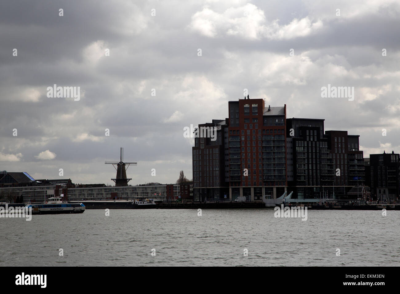Dutch medieval windmill and modern building in Dordrecht, South Holland ...