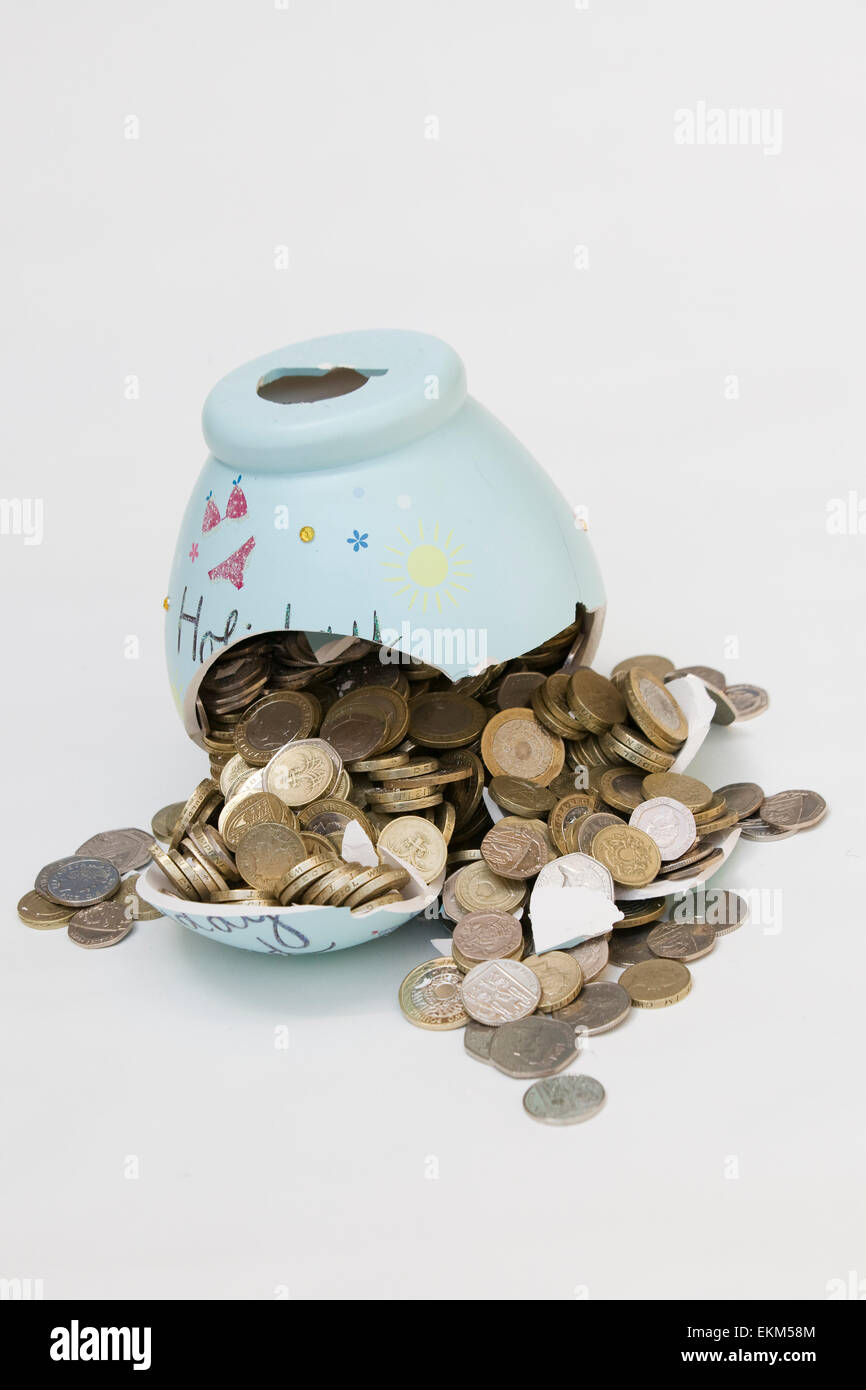 Smashed Money box with Coins pouring out of it on a white background ...