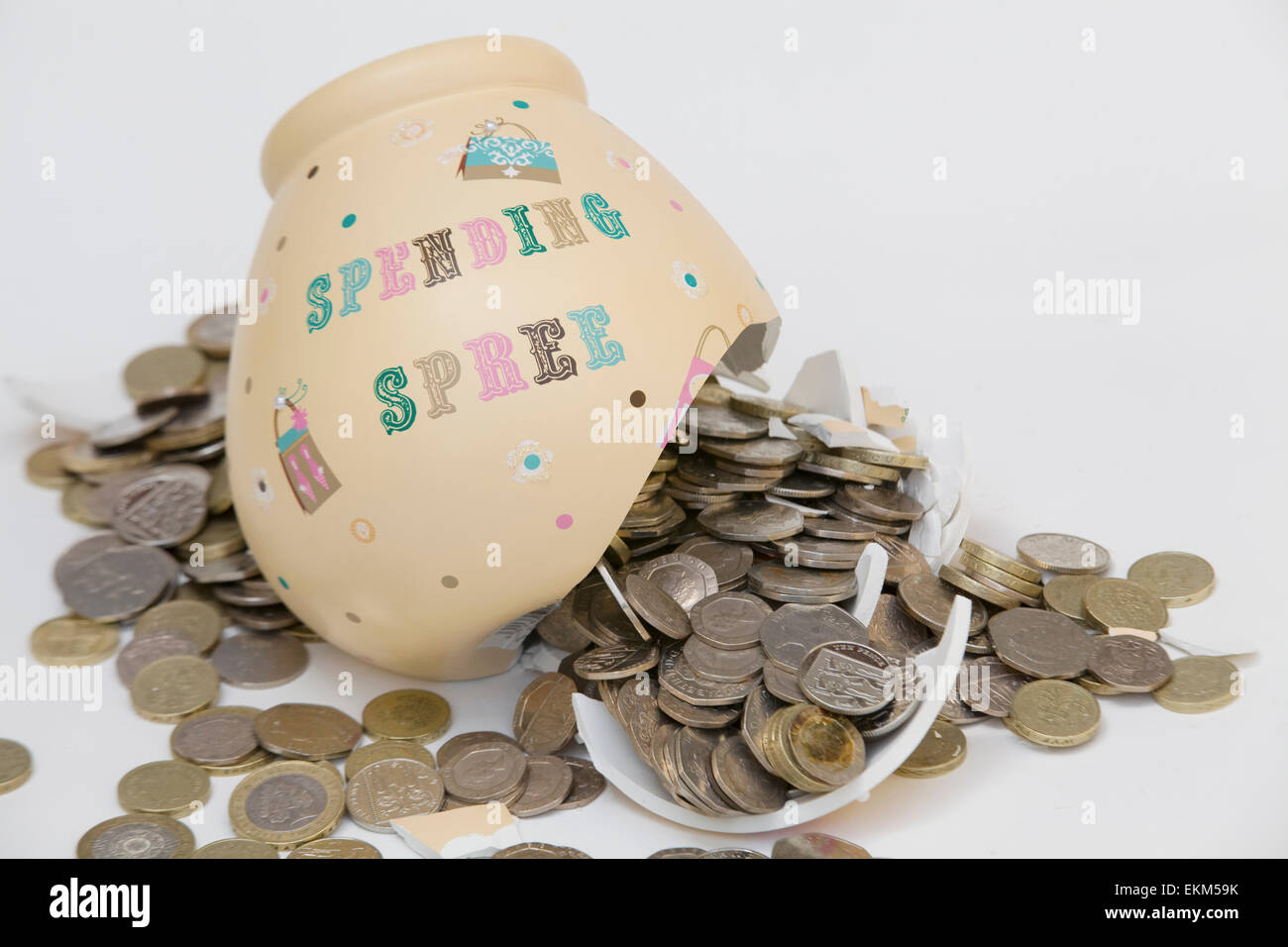 Smashed Money box with Coins pouring out of it on a white background ...