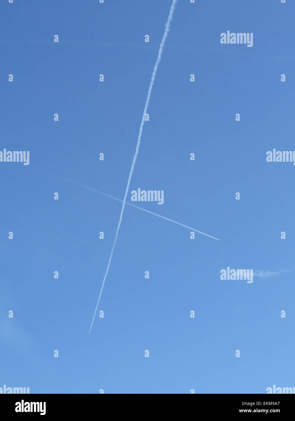Jet contrails / vapour trails against a blue sky Stock Photo - Alamy