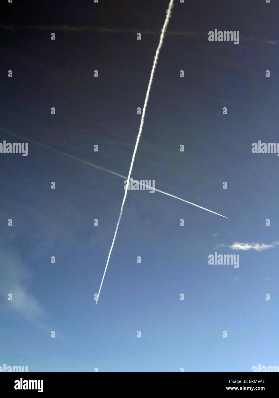 Jet contrails / vapour trails against a blue sky Stock Photo - Alamy