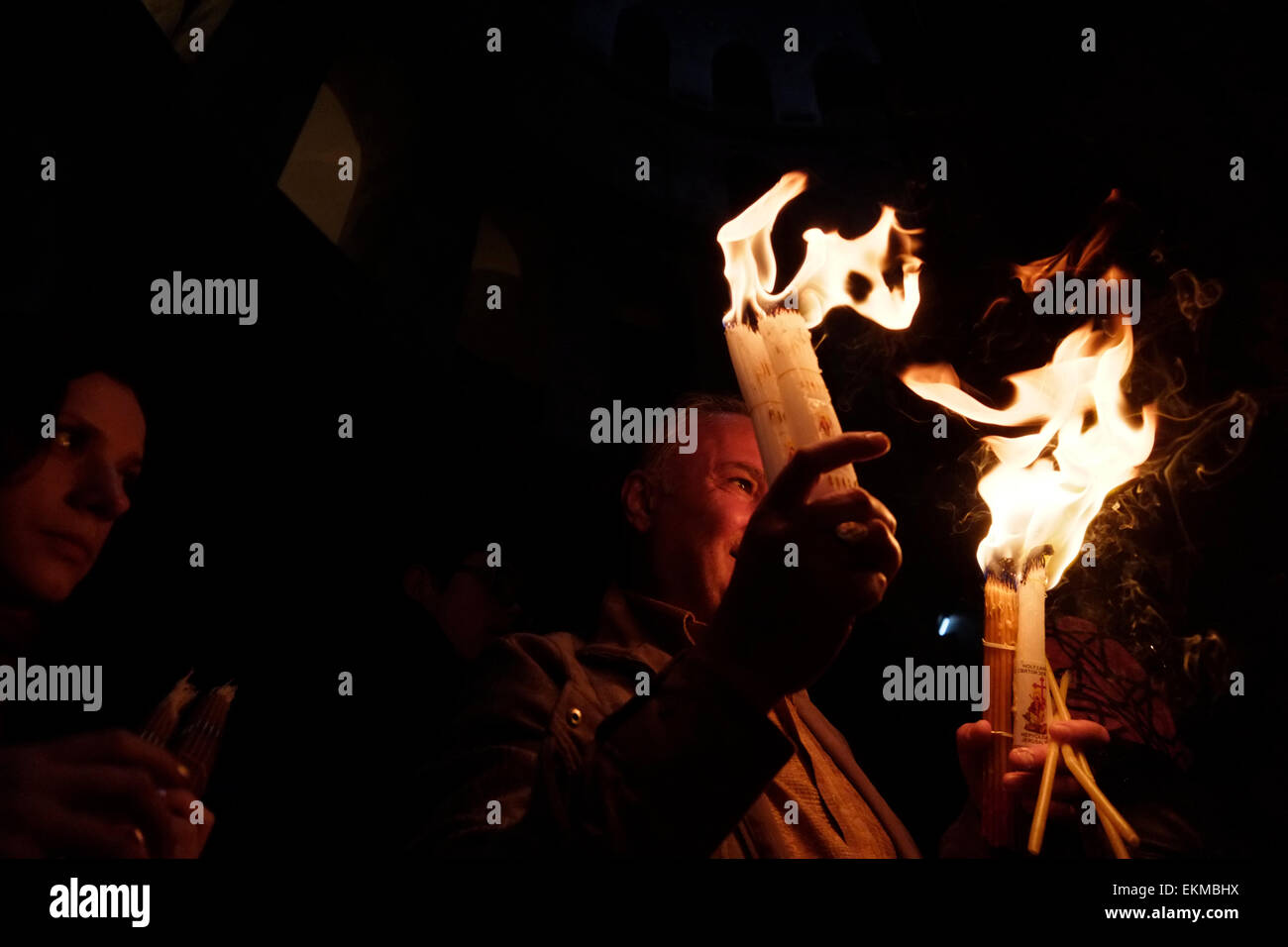 Christian Orthodox worshiper holds up candles lit from the Holy Fire ...