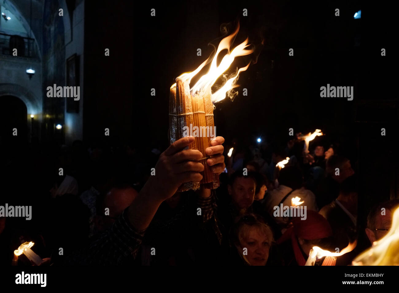 Christian Orthodox worshiper holds up candles lit from the Holy Fire ...