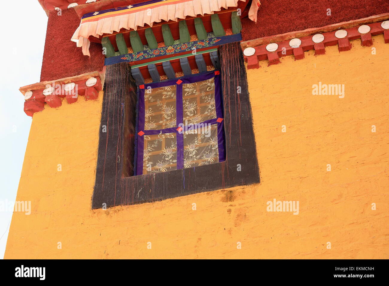 Classical tibetan window under canopy on a red and yellow painted wall ...