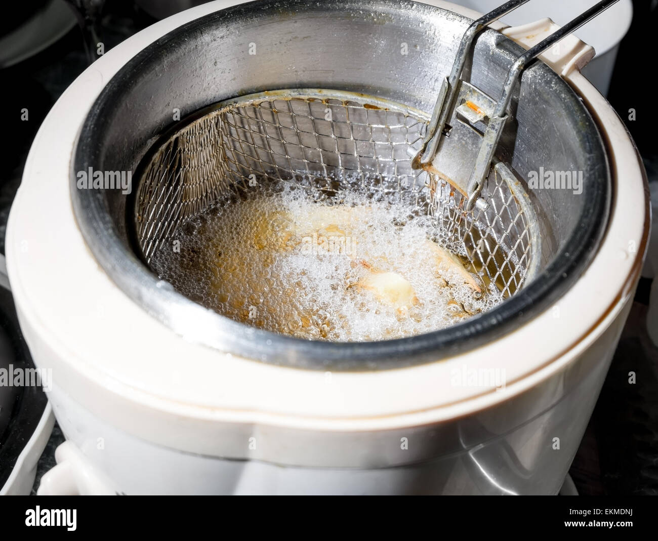 French fries cooking and bubbling in a deep fryer filled with oi Stock ...
