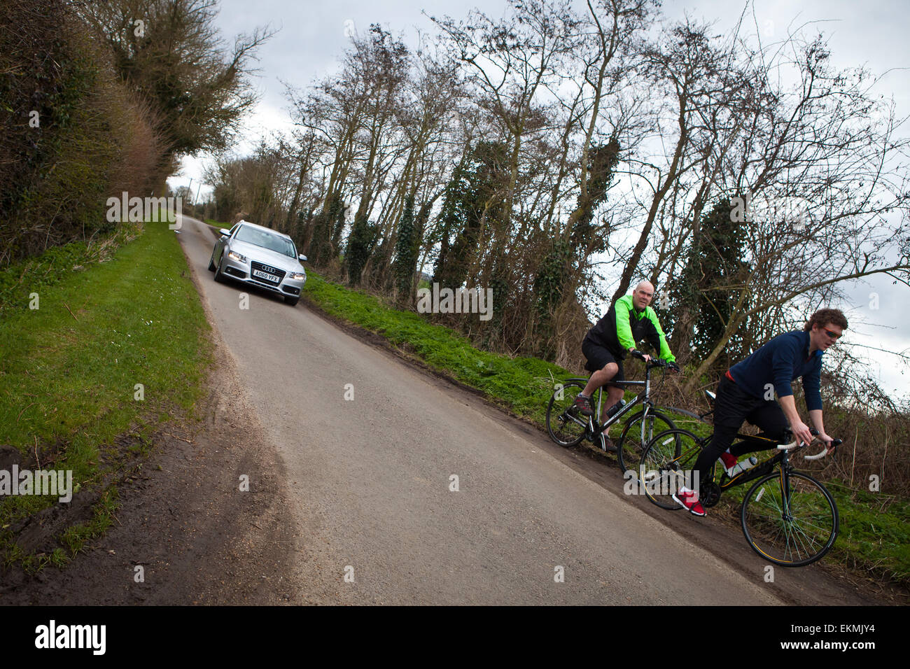 Cyclist about to be overtaken by car Stock Photo - Alamy