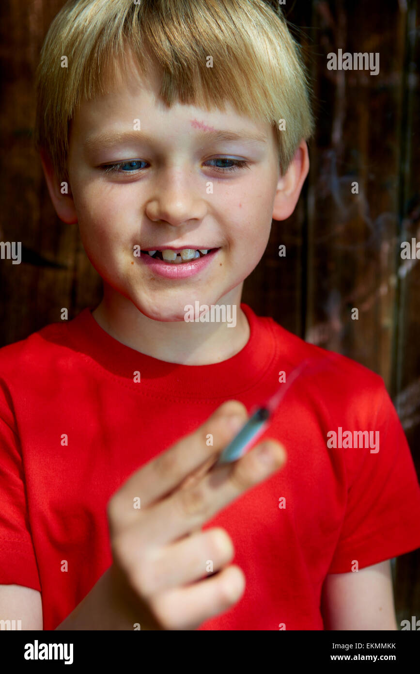 Portrait of Child blond boy smoking cigarette with dark wooden ...