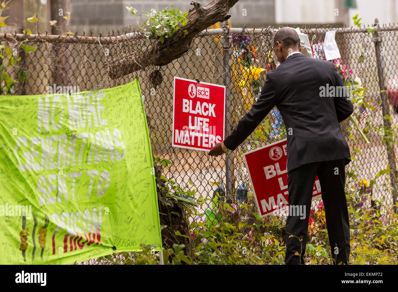 An activist adds signs to a makeshift memorial wall on the spot where ...