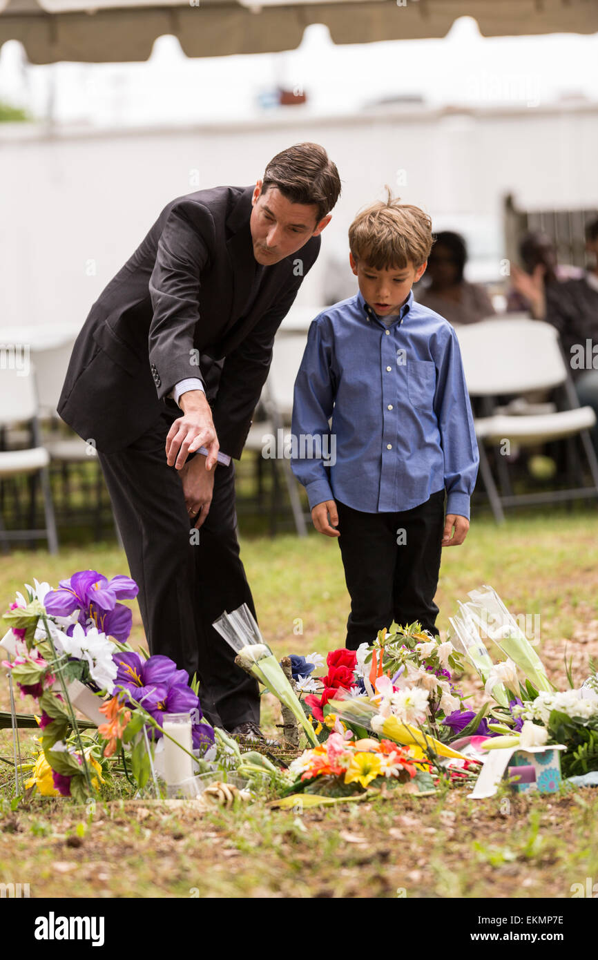 The Rev. Jeremy Rutledge and his son view a makeshift memorial on the ...