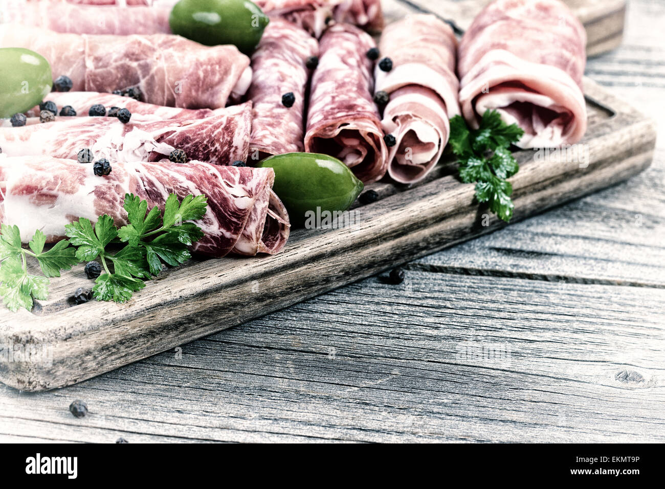 Vintage concept of various cold meats on serving board with ham, pork ...