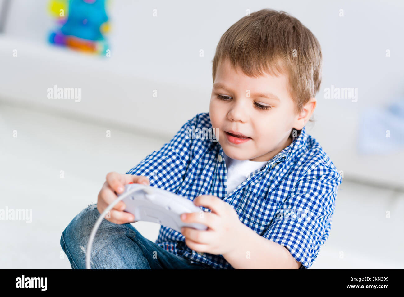 Boy playing on a game console Stock Photo - Alamy