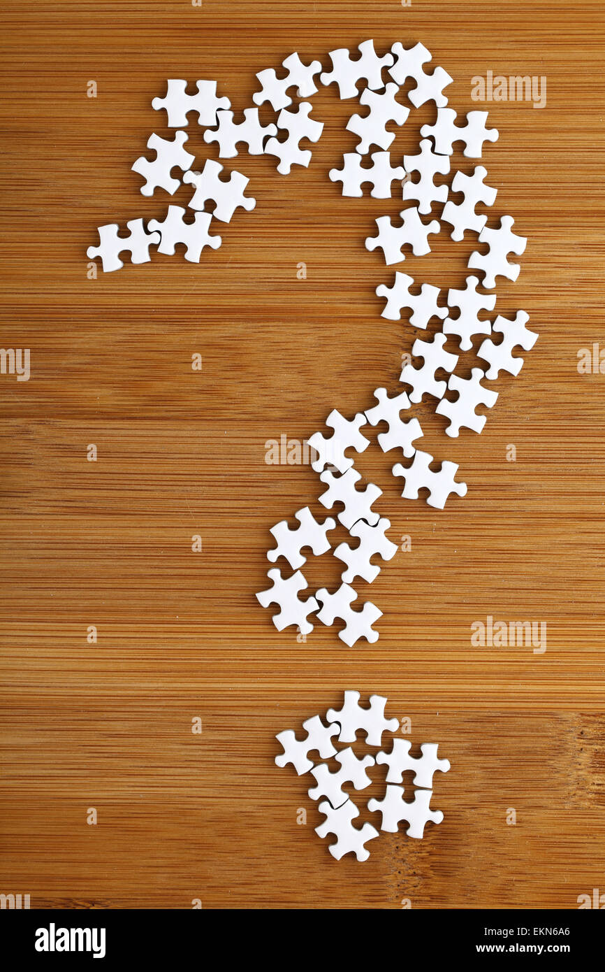 Question mark made by puzzle on wood background Stock Photo - Alamy