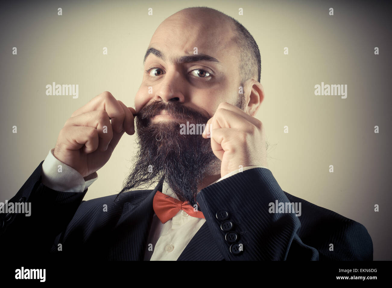 Funny elegant bearded man touching mustache Stock Photo - Alamy