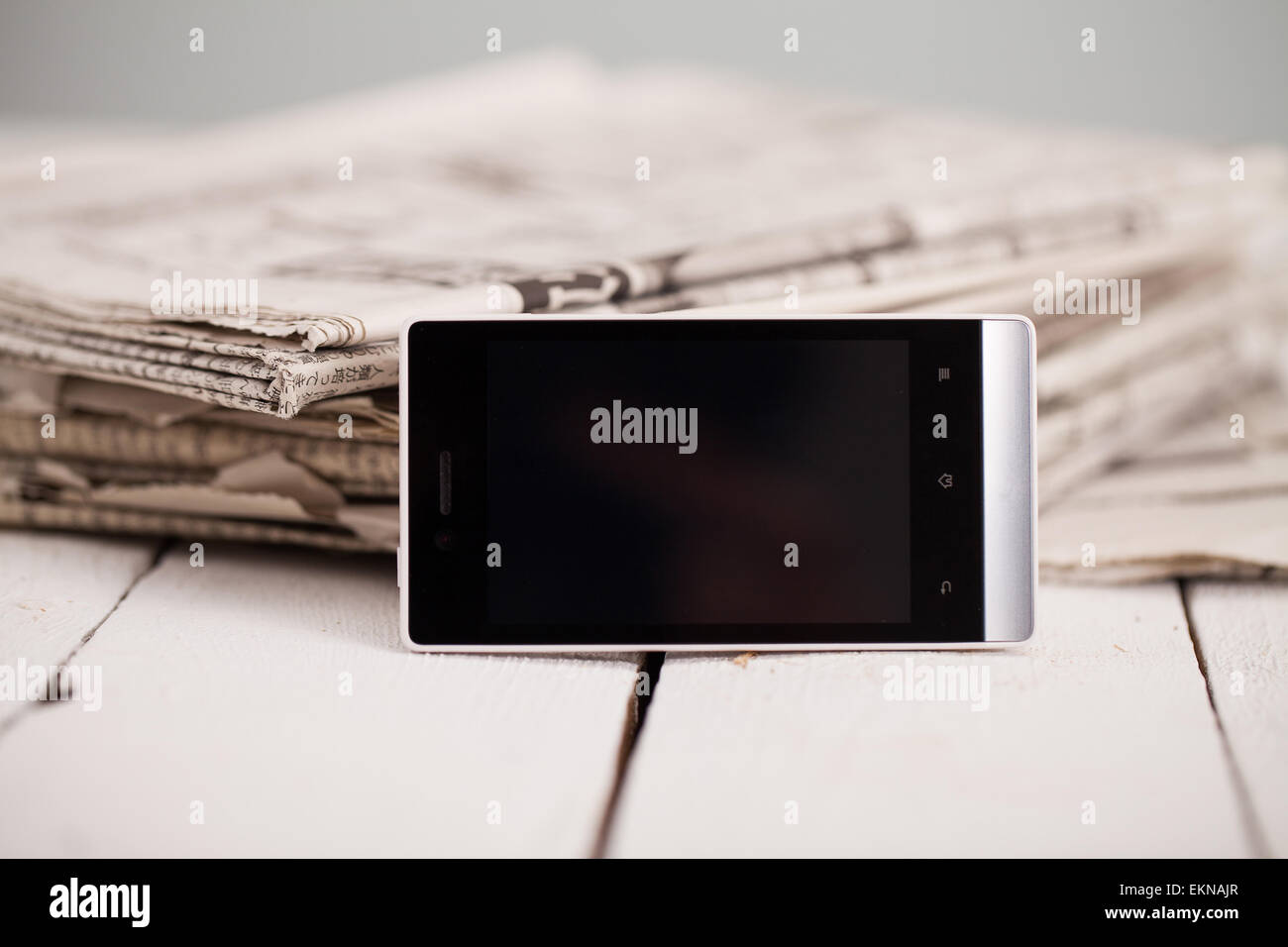 Pile of newspapers with smartphone on it Stock Photo - Alamy