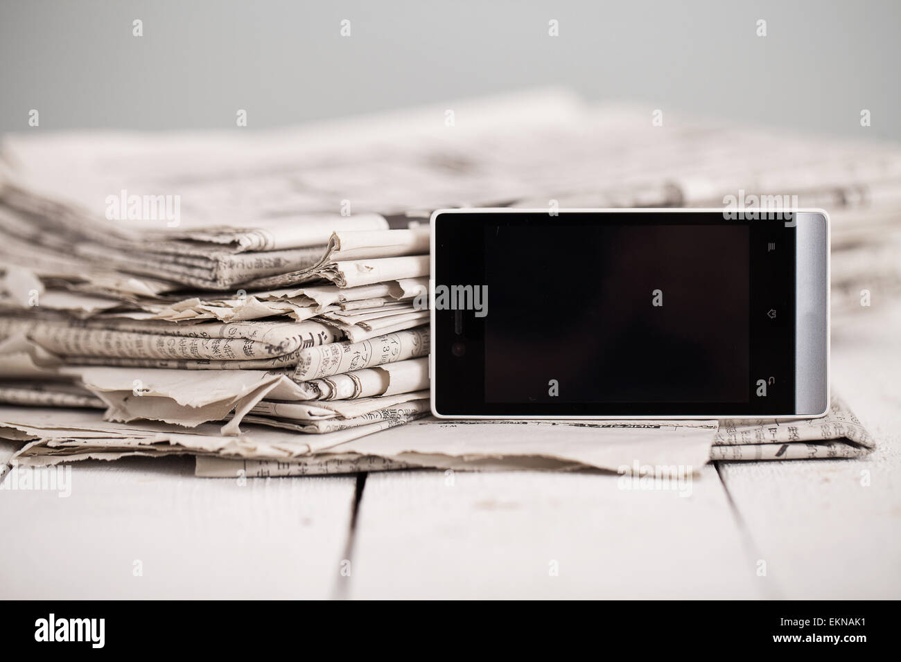 Pile of newspapers with smartphone on it Stock Photo - Alamy