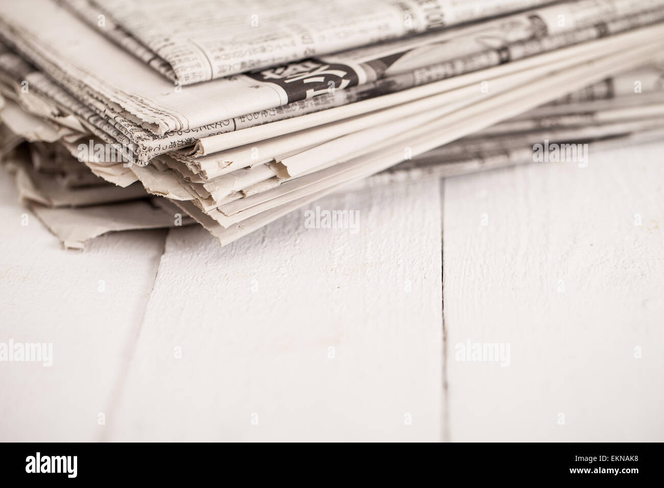 Pile of newspapers on a white table Stock Photo - Alamy
