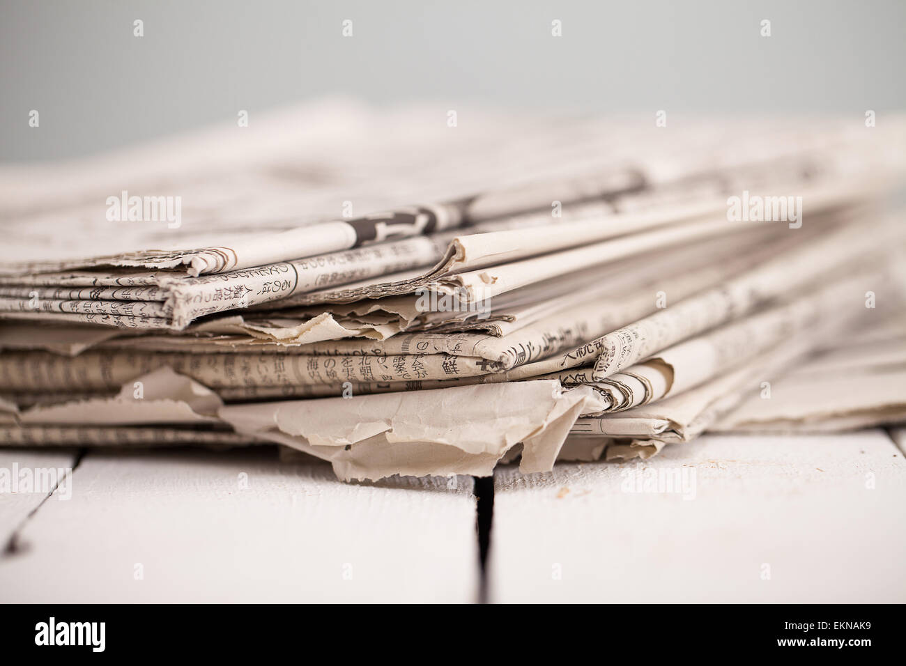 Pile of newspapers on a white table Stock Photo - Alamy