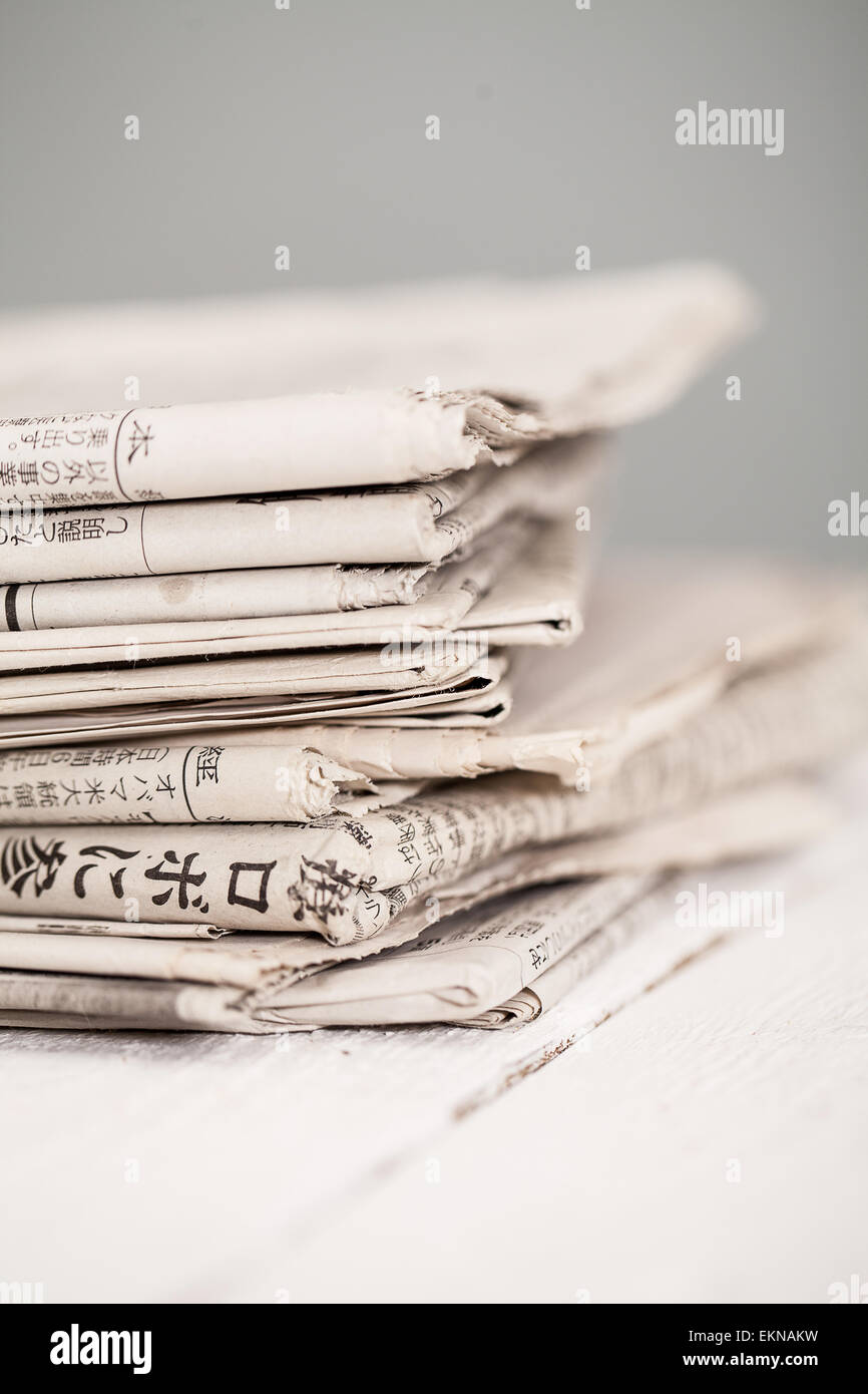Pile of newspapers on a white table Stock Photo - Alamy