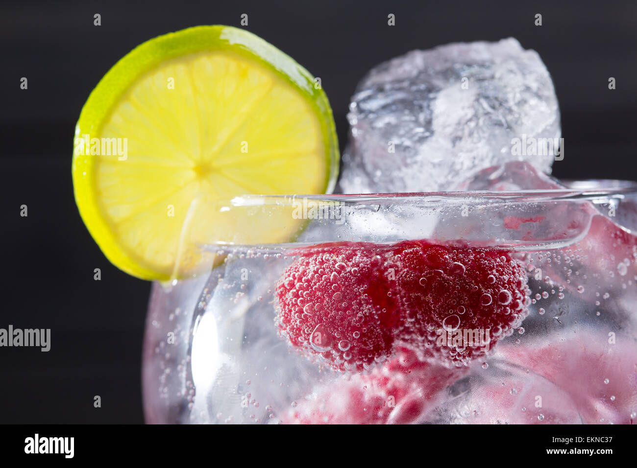 Gin tonic cocktail with raspberry and ice macro closeup Stock Photo - Alamy