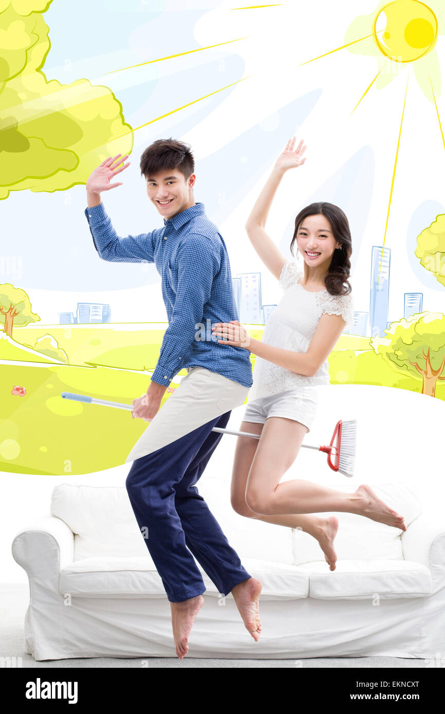 Happy young couple flying on broom Stock Photo - Alamy