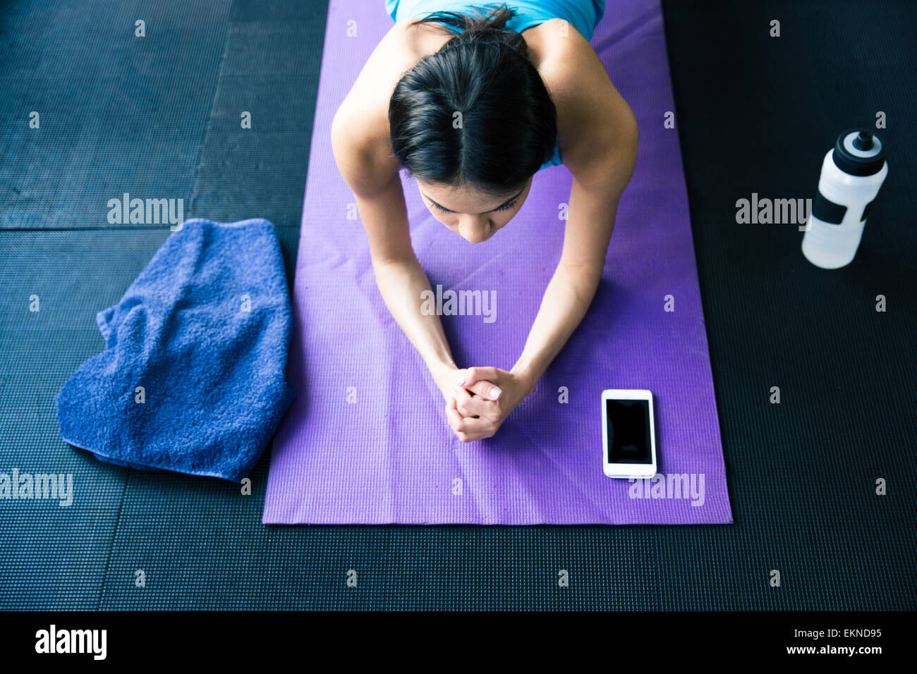 Top view portrait of a young woman doing yoga exercises on yoga mat at ...