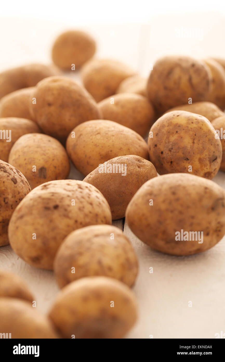Rustic unpeeled potatoes on a table Stock Photo - Alamy