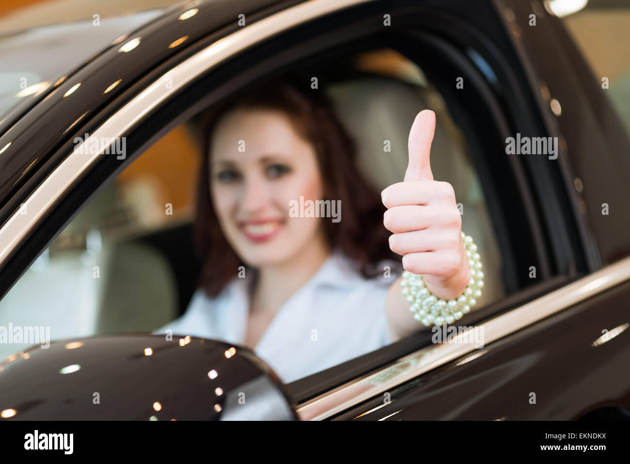 young woman in a car and showing a thumbs up Stock Photo - Alamy